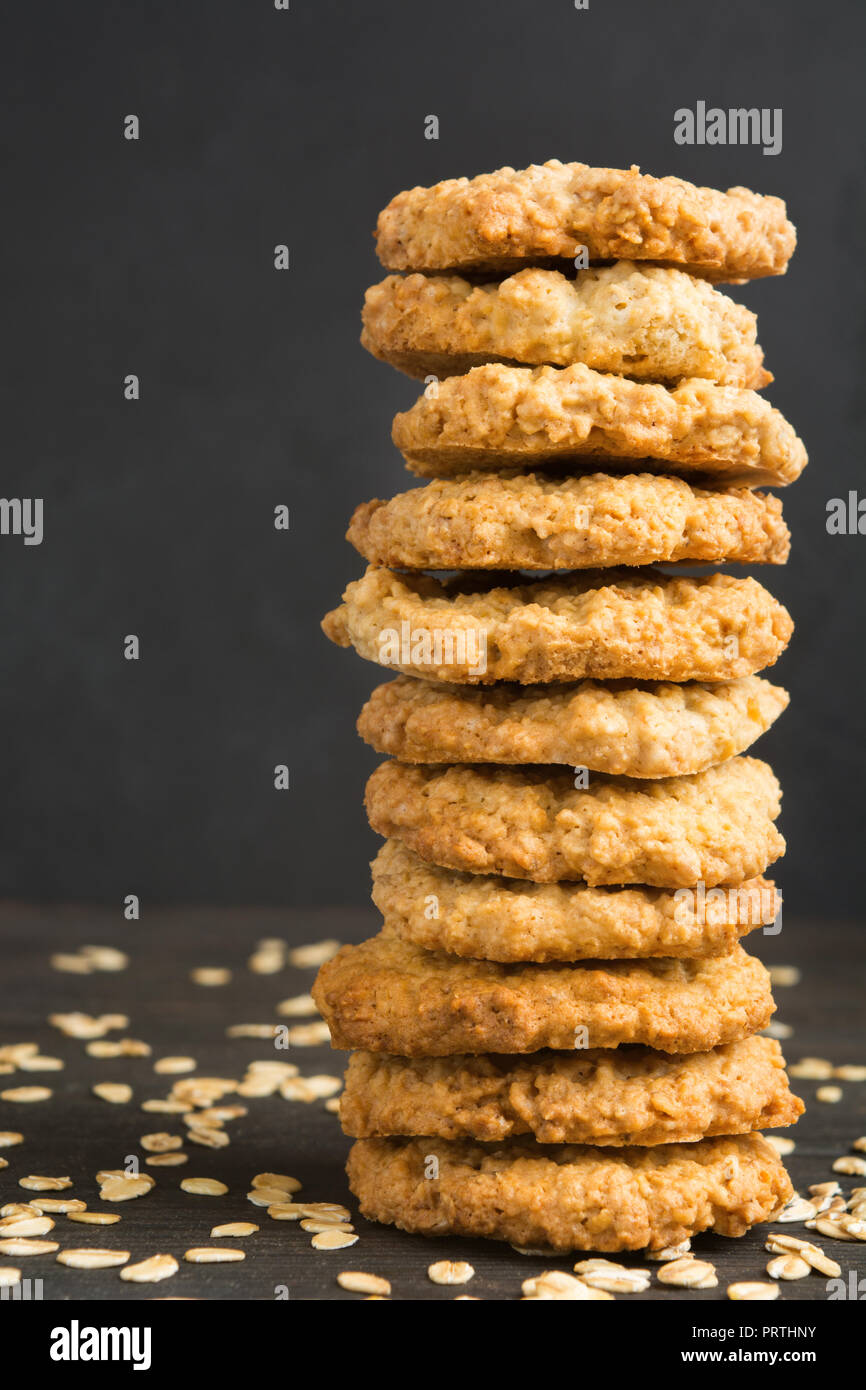 A big stack of homemade cookies of oat on dark background with copy ...