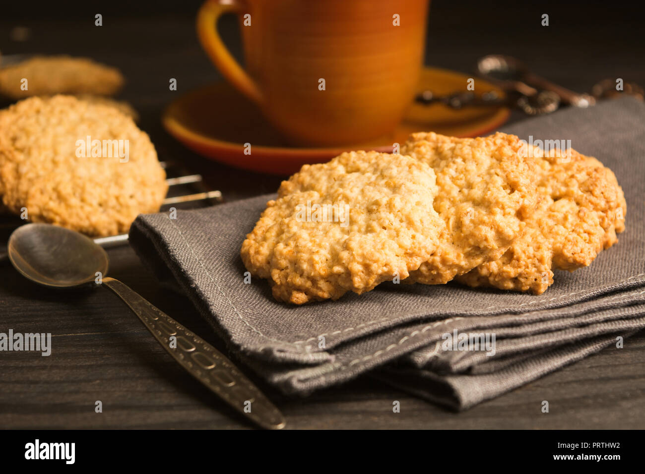 Sweet cookies with oat on tissue with tea or coffee in brown cup ...