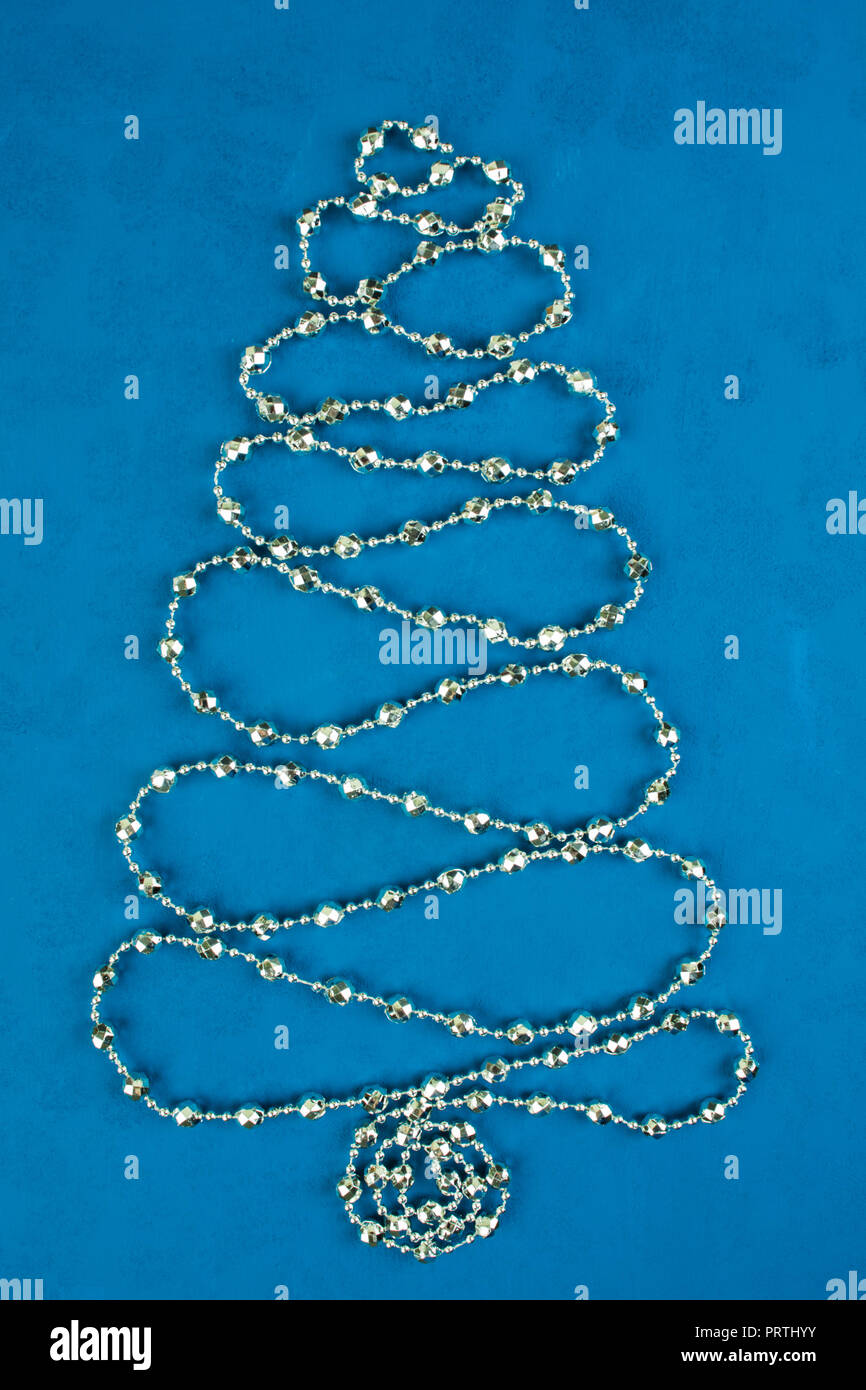Christmas decoration tree of silver shine garland over blue background ...