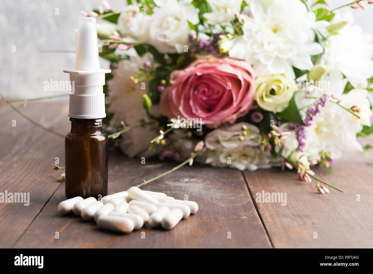 Allergy concept with spray and pills against pollen disease over wooden ...