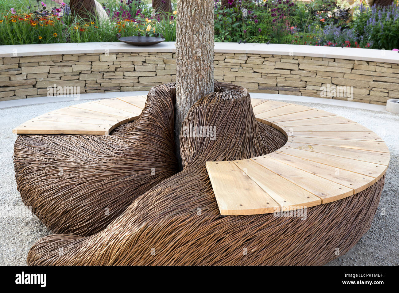 Garden with a Circular patio design with Woven willow and wooden bench ...