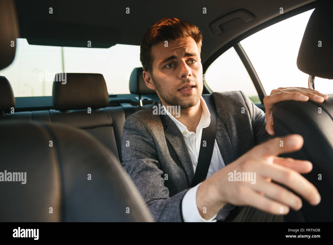 Young business man passenger showing taxi driver the way Stock Photo ...