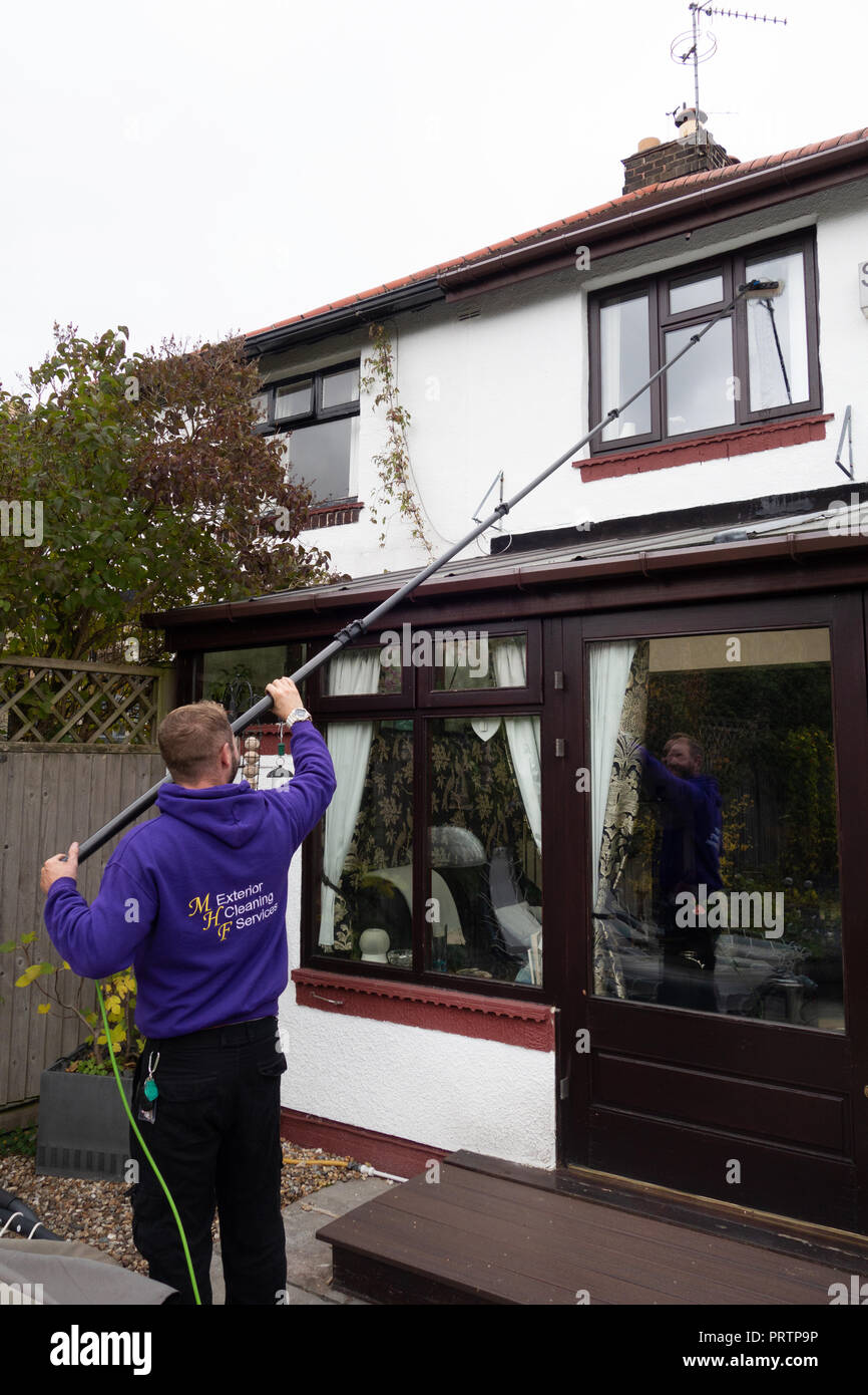 Window Cleaner using the ‘reach and wash’ system (water-fed pole and ...