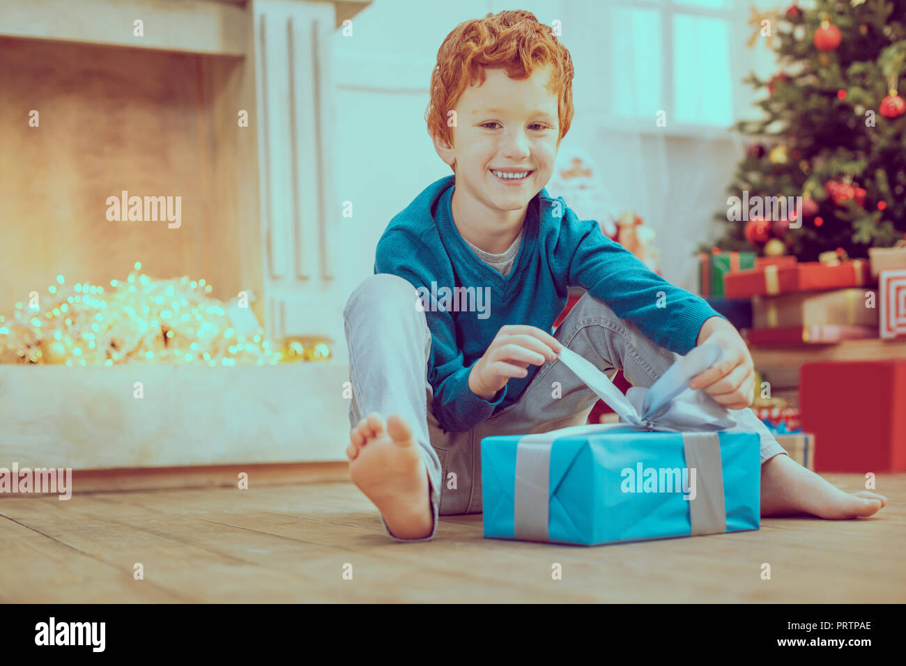 Cheerful boy playing with grey ribbon Stock Photo - Alamy
