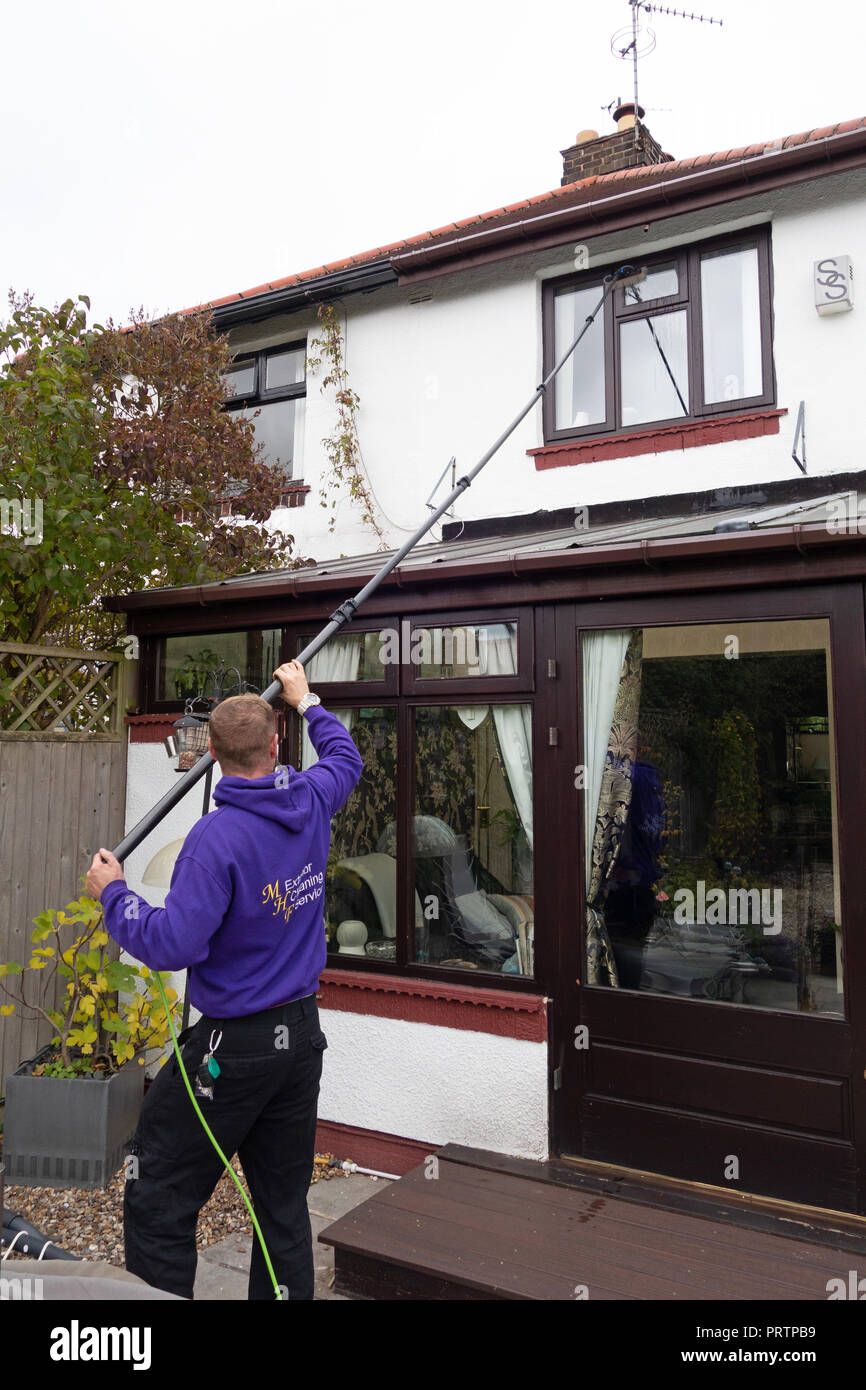Window Cleaner using the ‘reach and wash’ system (water-fed pole and ...