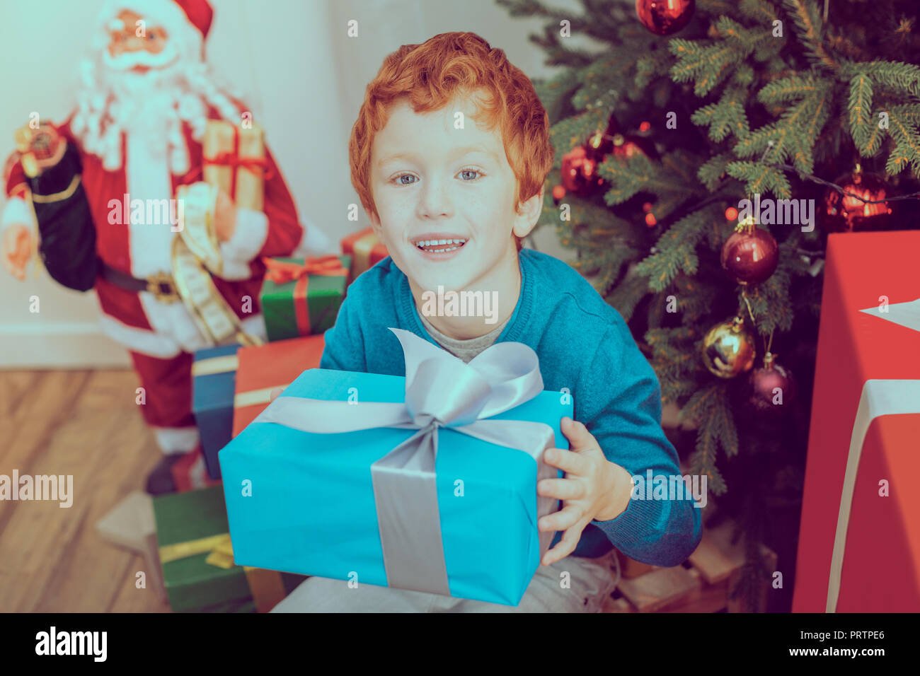 Positive delighted child sitting between presents Stock Photo - Alamy