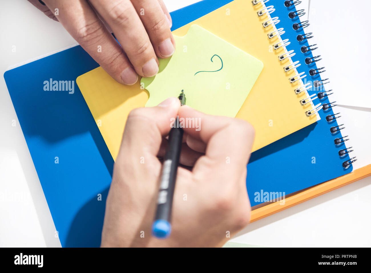 close up of human hands drawing exclamation mark on note with pen ...