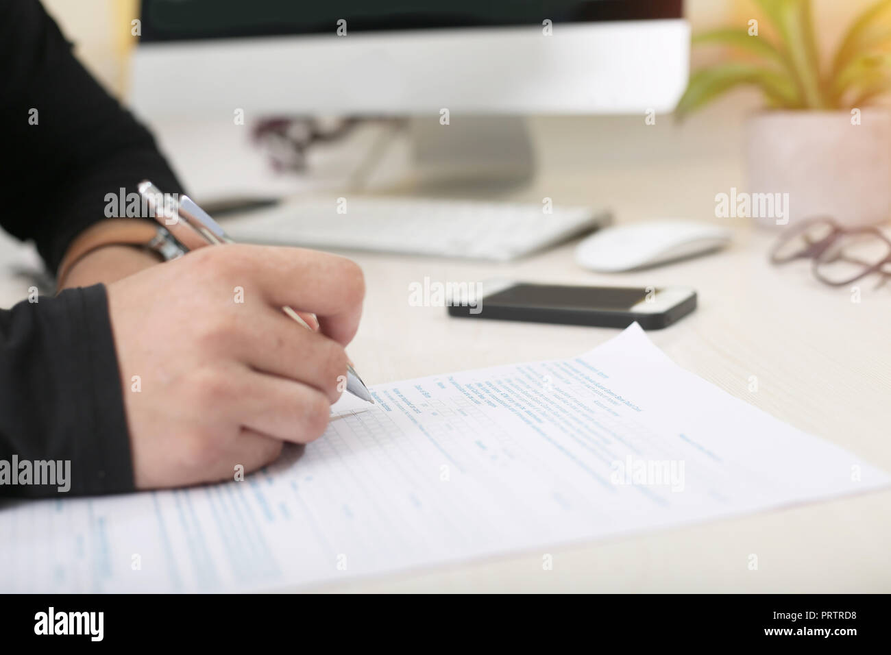 Man is filling a form with pen Stock Photo - Alamy