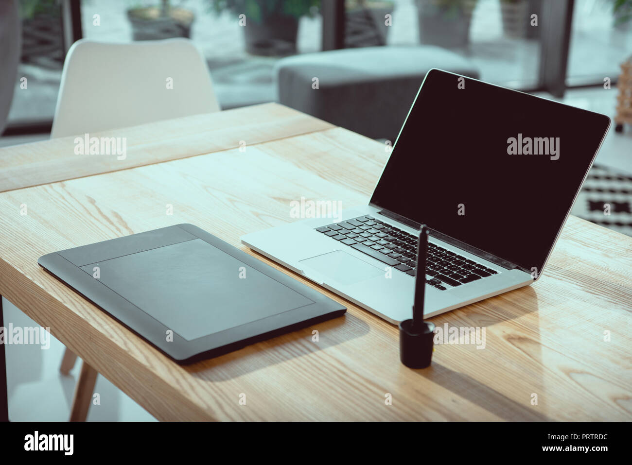 laptop with blank screen and graphics tablet on wooden tabletop at ...