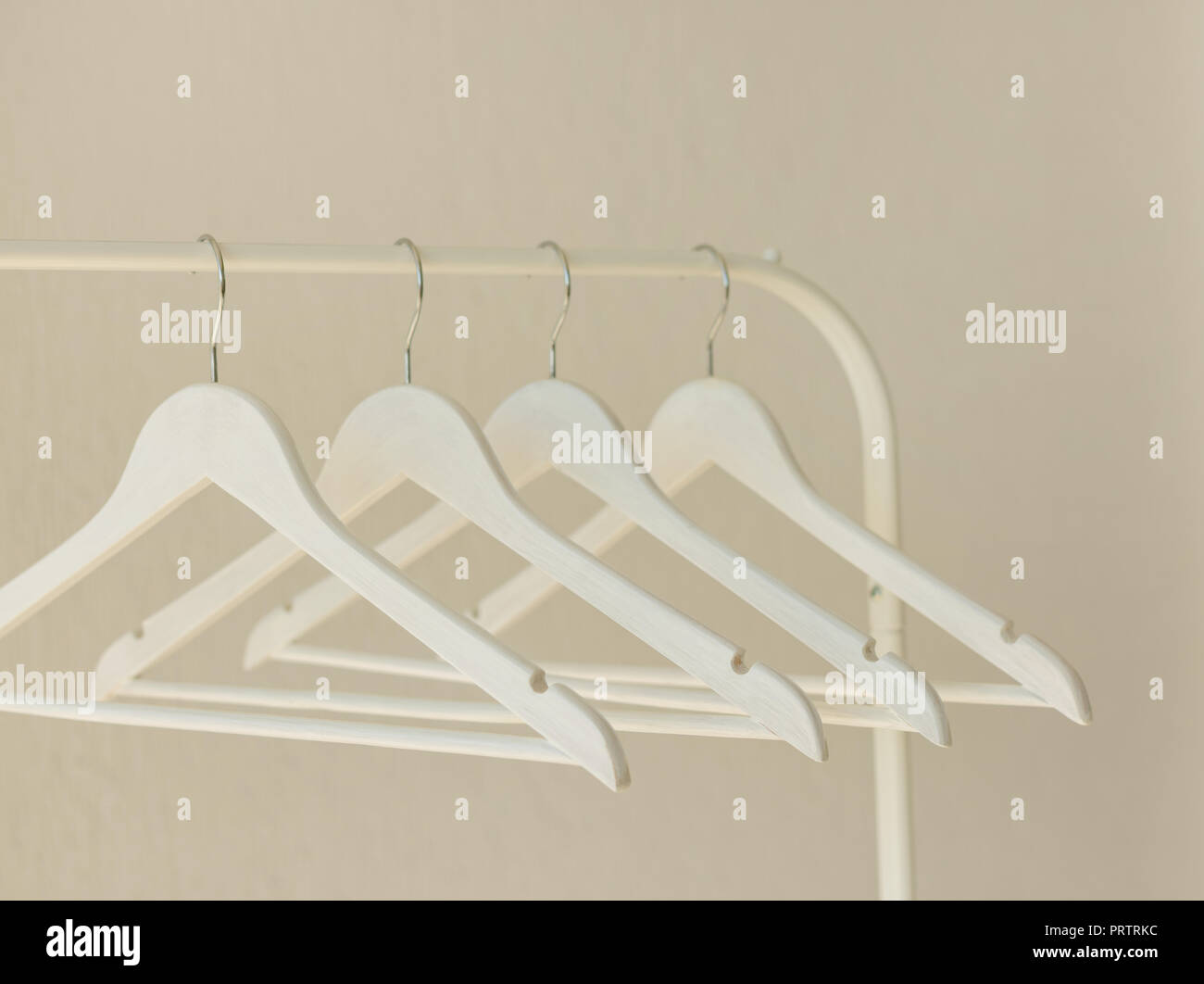 White row of hangers on the rack. Selective focus Stock Photo - Alamy