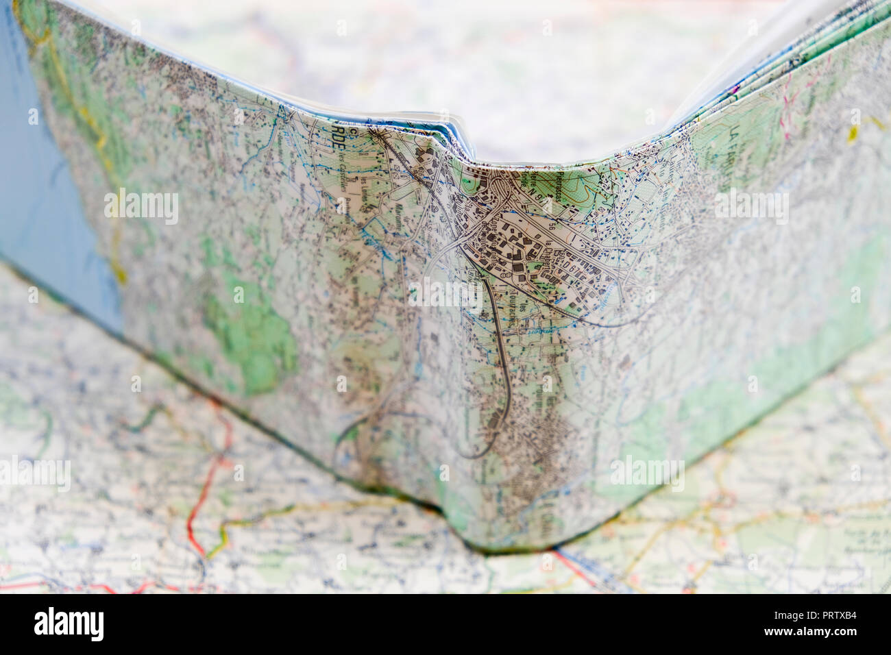 Road maps, one map standing sideways on top of the other, selective ...