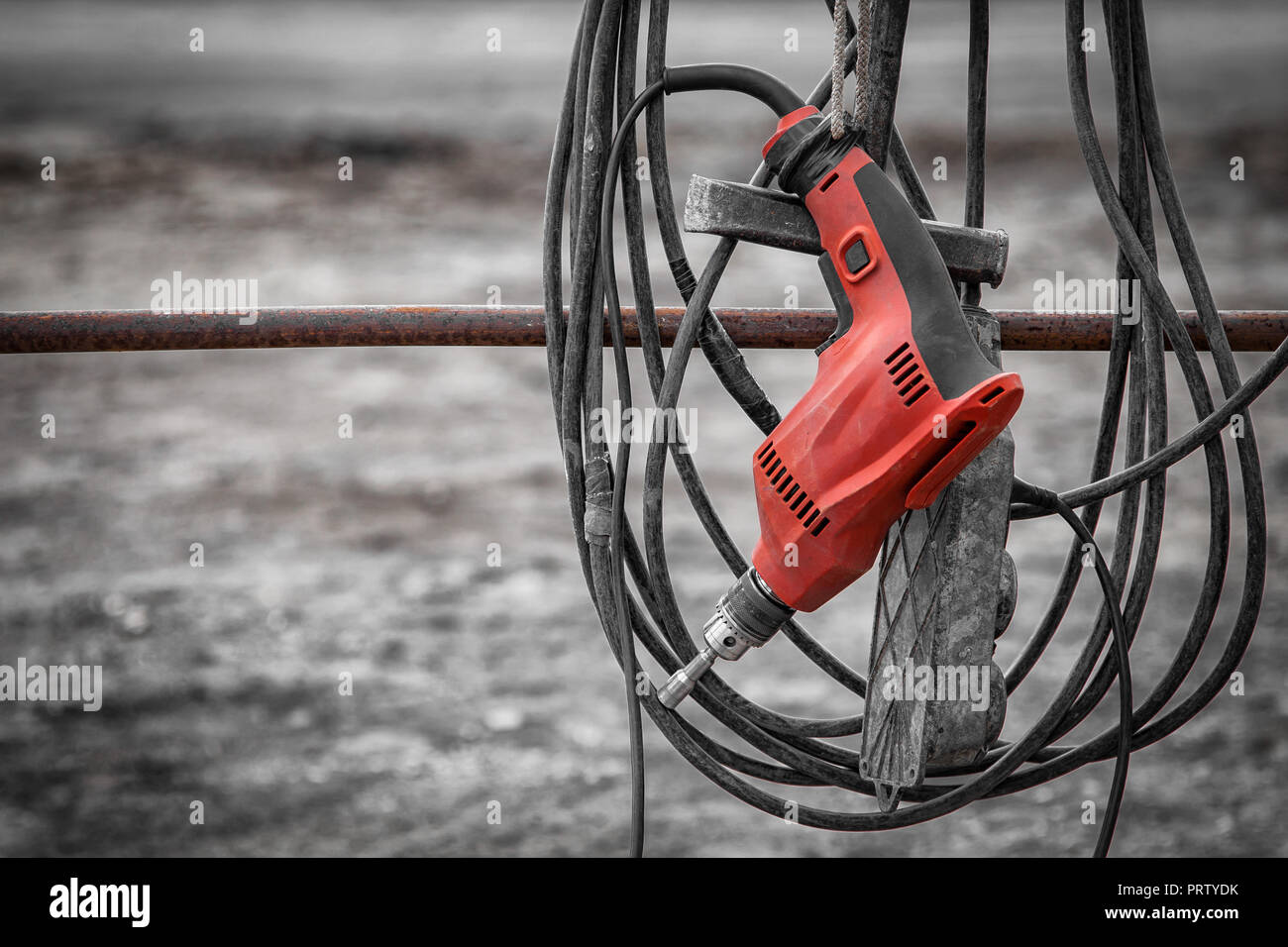 Close-up of a new modern red drill with a long wire wrench attachment ...