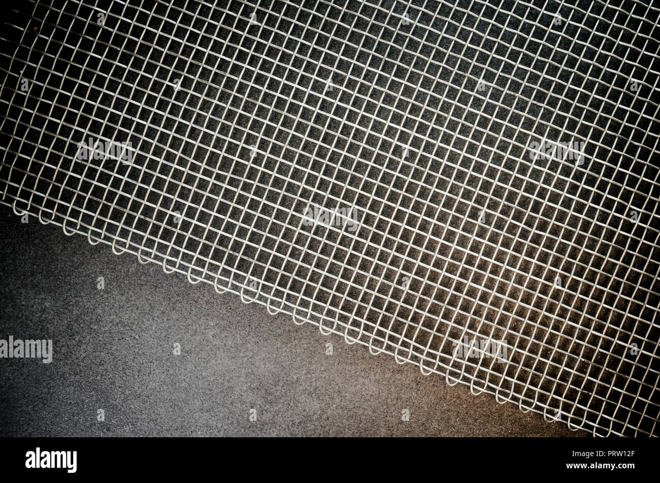 metallic mesh on a dark stone surface - repeating pattern Stock Photo ...