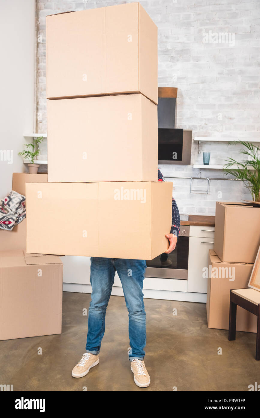 man holding stack of cardboard boxes while moving home Stock Photo - Alamy