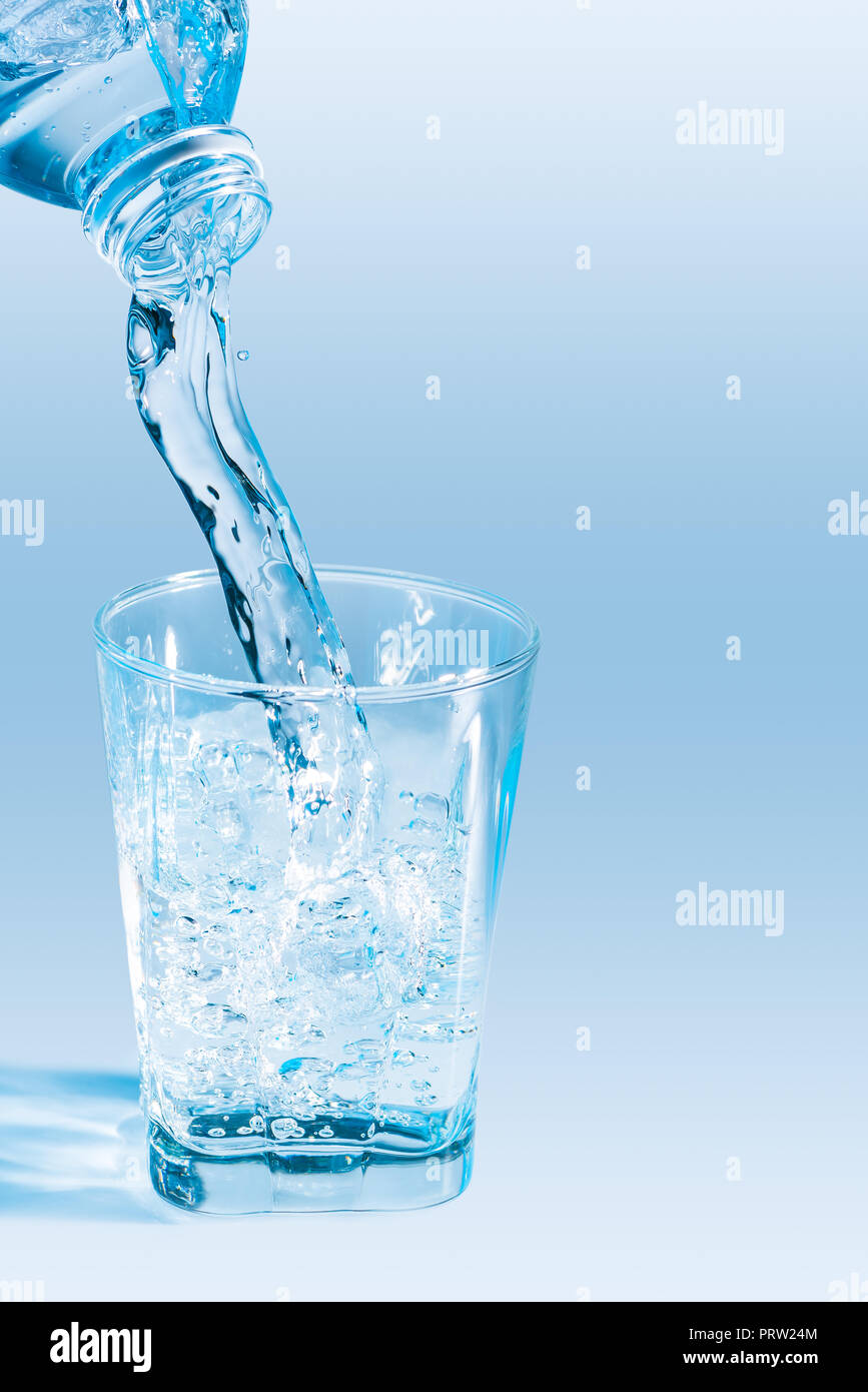 The bottle drinking water is being poured into the glass Stock Photo ...