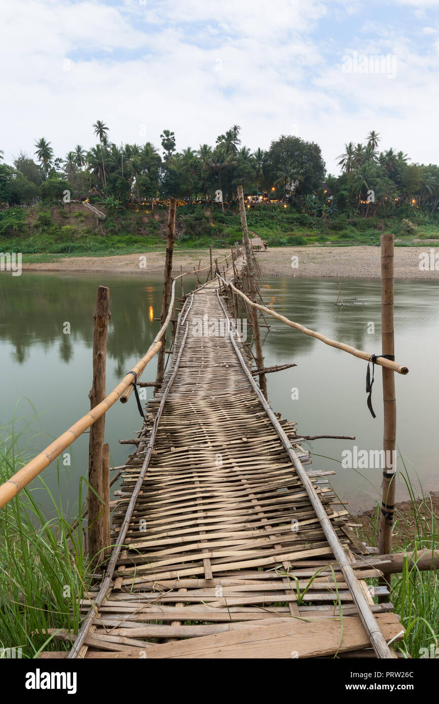 Wooden bamboo bridge over Nam Khan River at low tide viewed from the ...