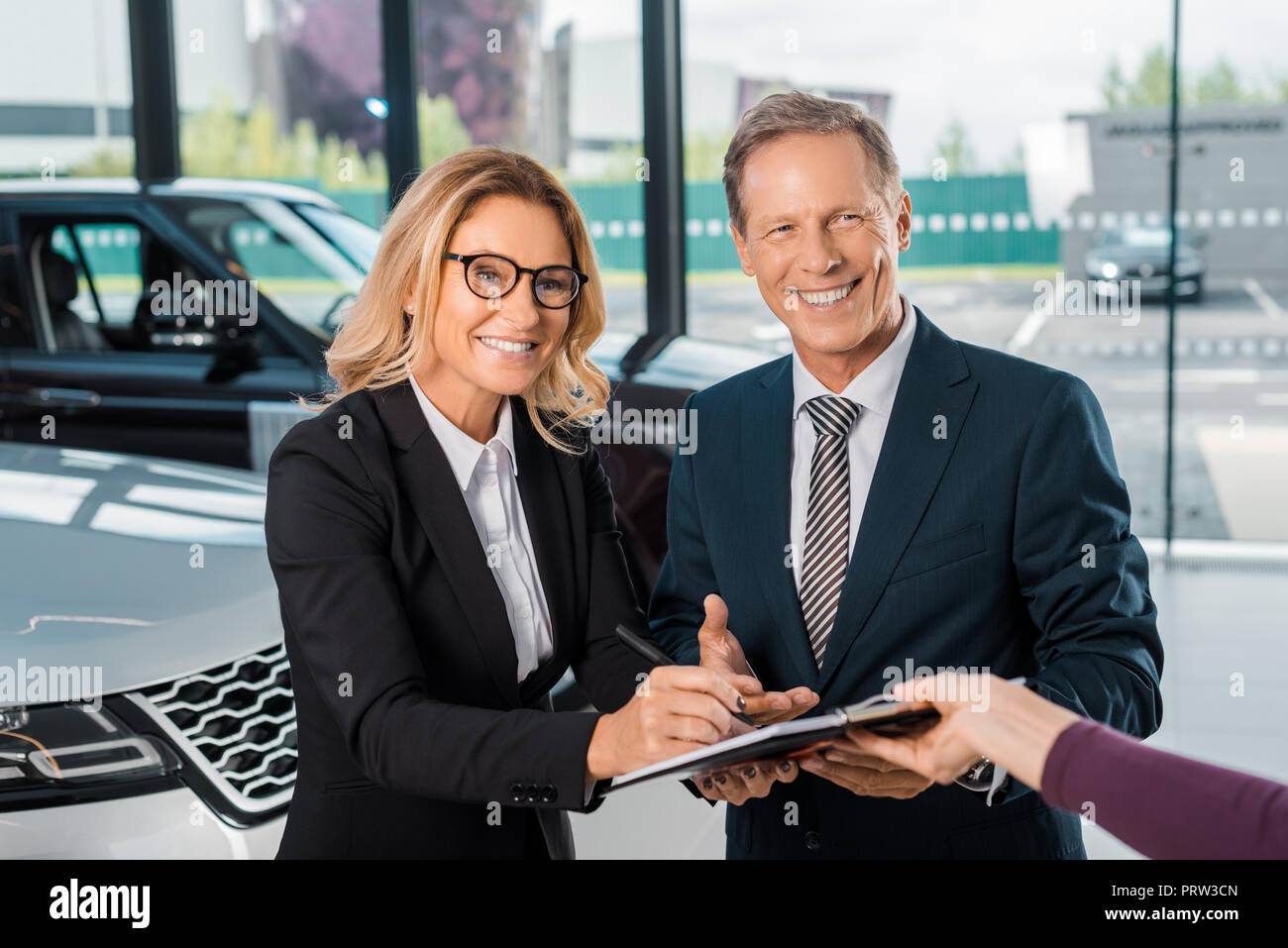 Signing papers at dealership hi-res stock photography and images - Alamy