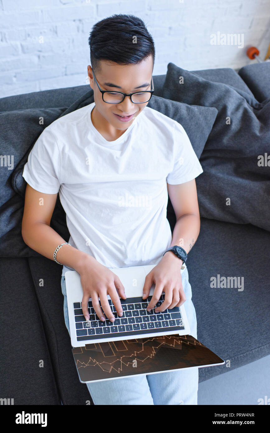 high angle view of handsome asian man using laptop with chart appliance ...