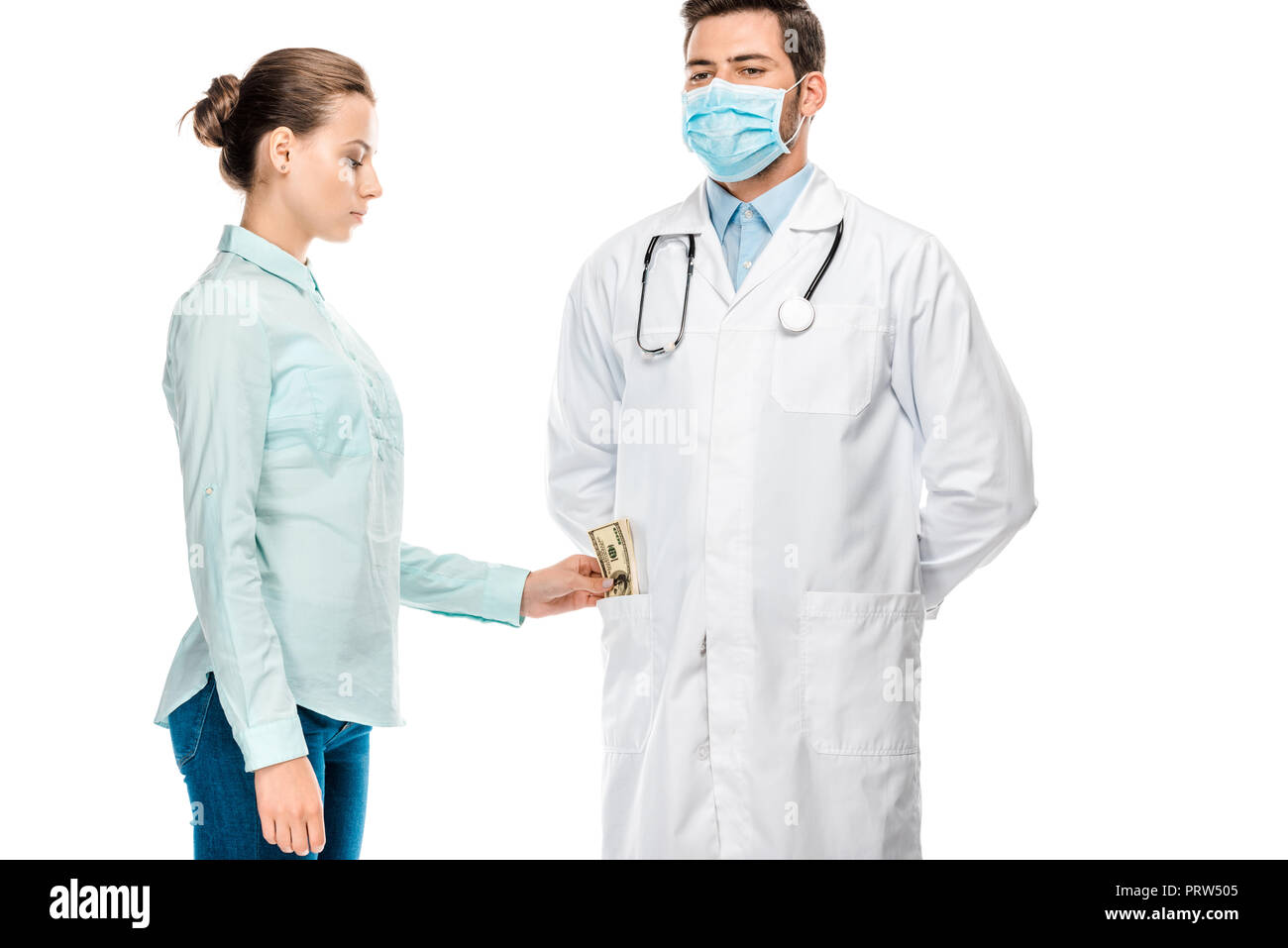 side view of female patient putting bribe in pocket of young male ...