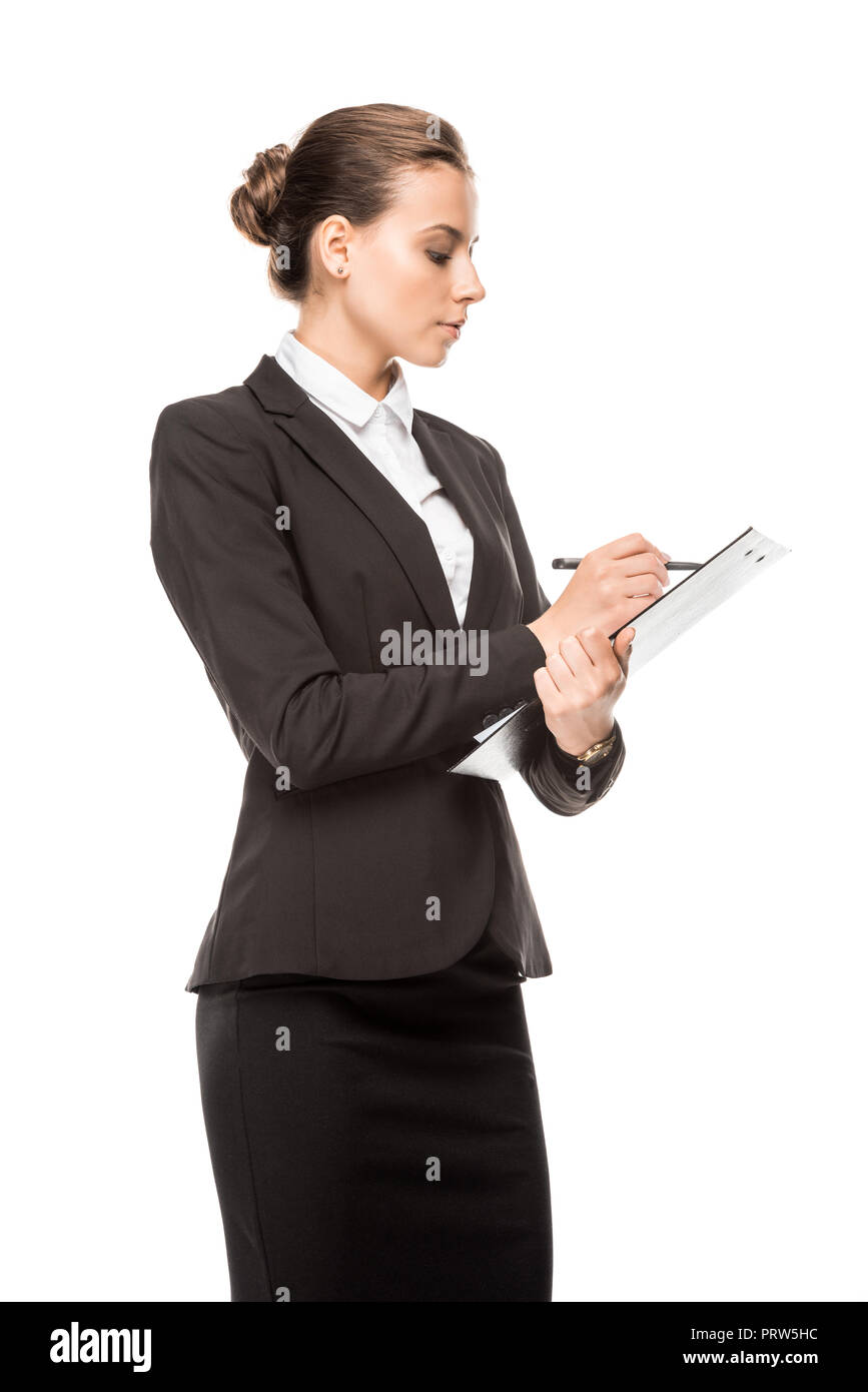 side view of beautiful young businesswoman writing in clipboard ...