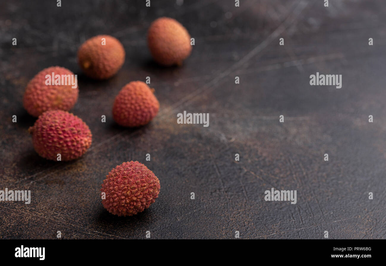 Some fresh ripe lychees over dark rustic background Stock Photo - Alamy