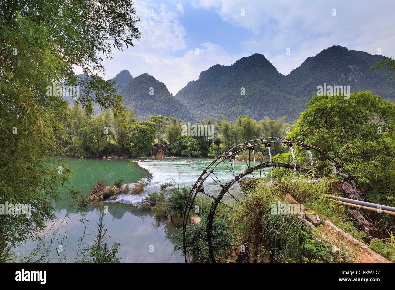 Bamboo water wheel gets water from the river to irrigate rice fields ...