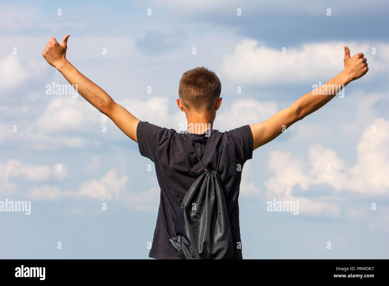happy young man standing on top with his hands up, success Stock Photo ...