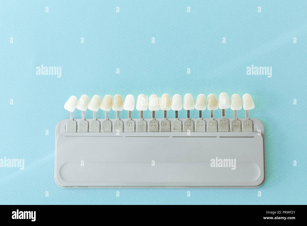 Plastic dental implant for choose color tone of teeth on blue ...