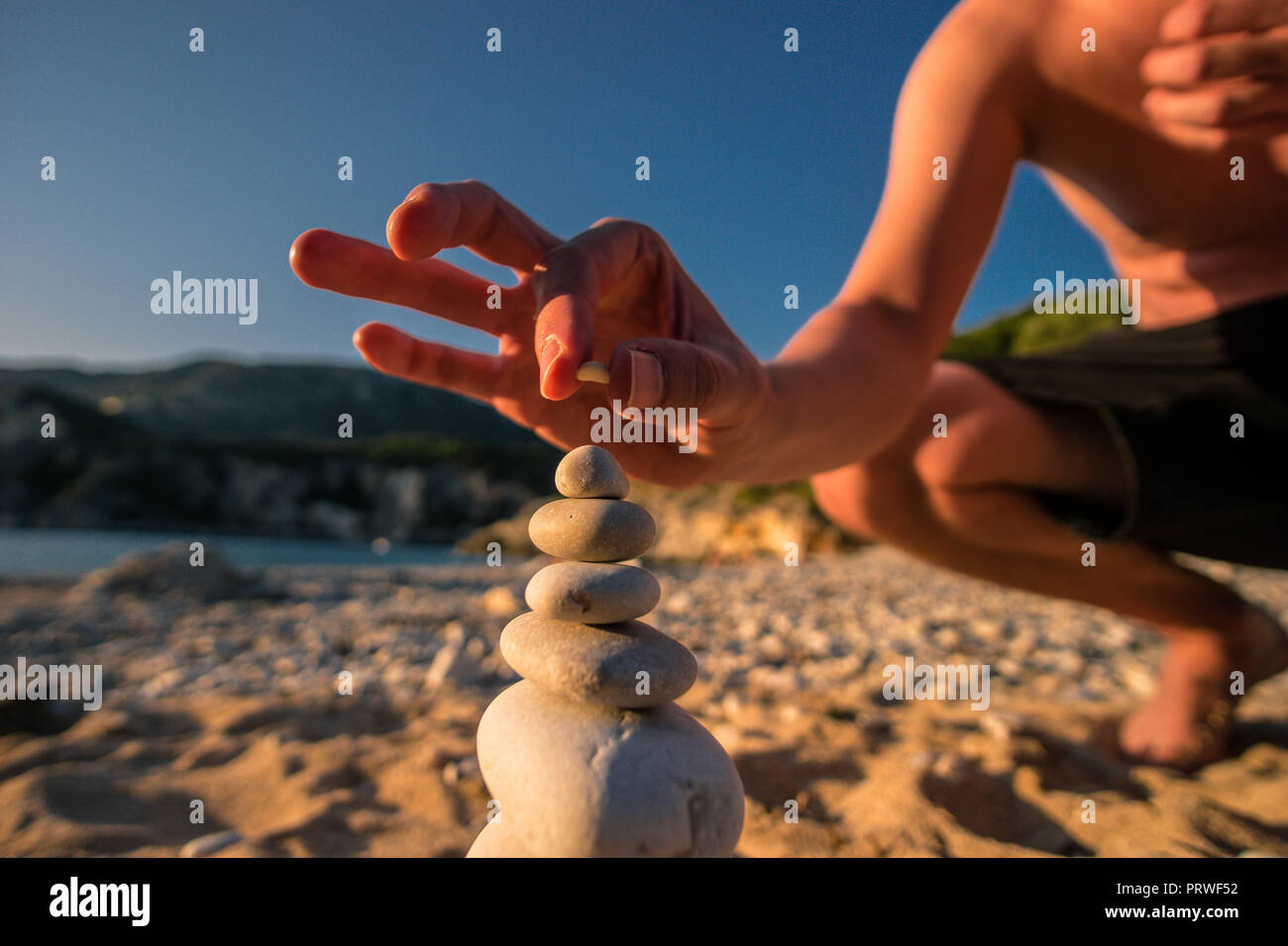 man builds a stone pyramid Stock Photo - Alamy