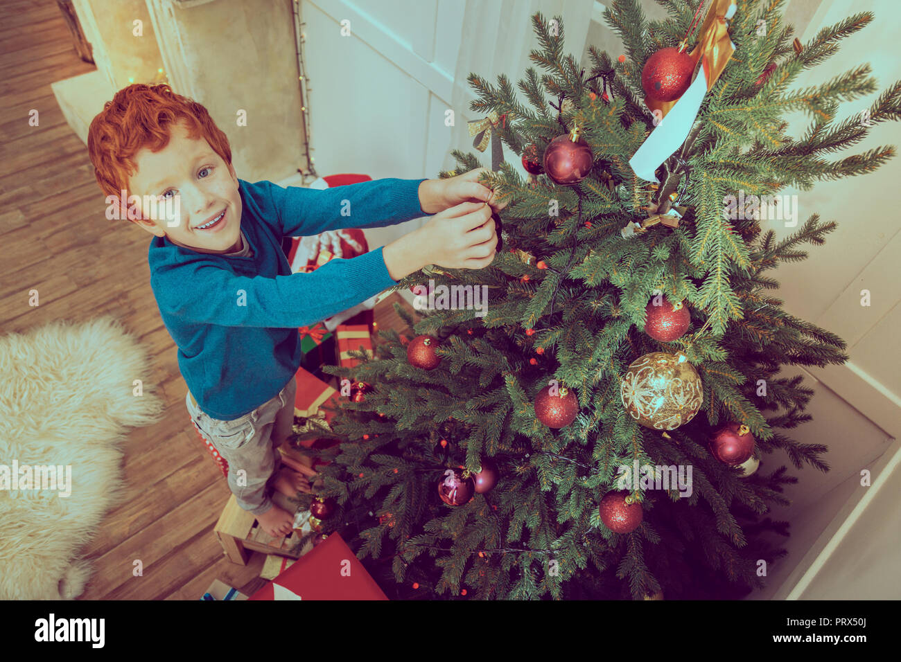 Top view photo of delighted child that decorating tree Stock Photo - Alamy