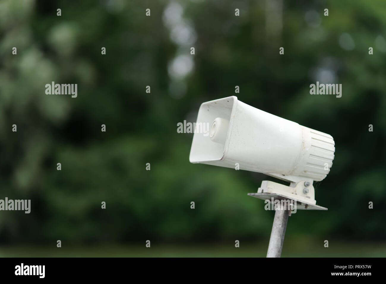 White megaphone on a mast against green forest Stock Photo - Alamy