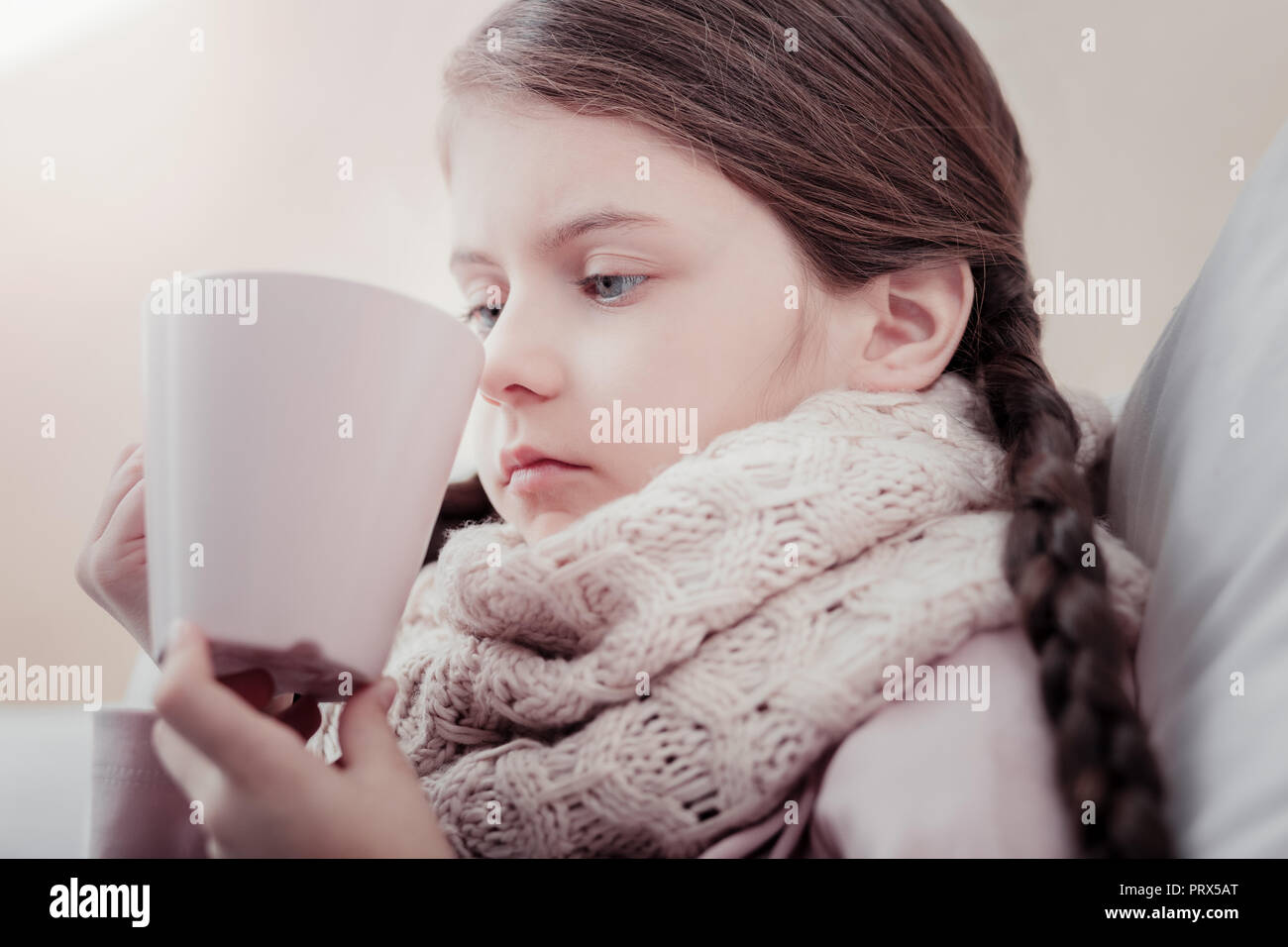 Little girl with a cup of tea expressing indifference Stock Photo - Alamy