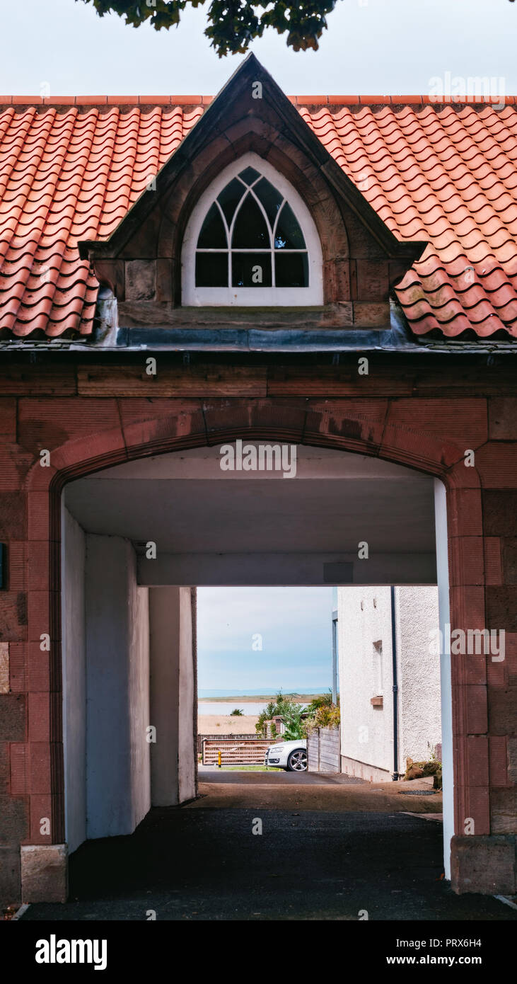 The entrance of a beautiful old house with a tiled roof and an arched ...