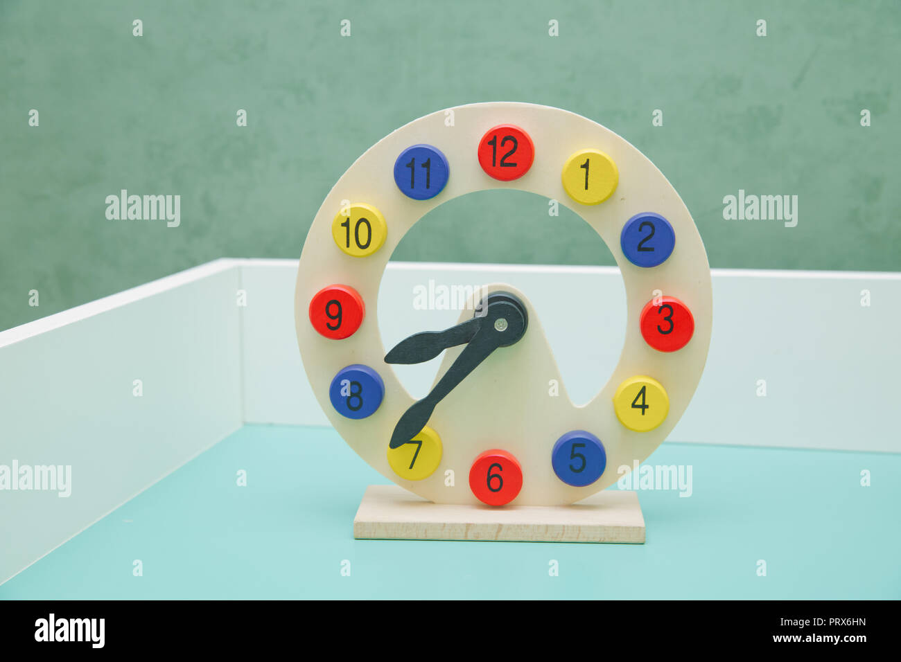 Colorful wooden toy clock in textured foam for kid to learn about the ...