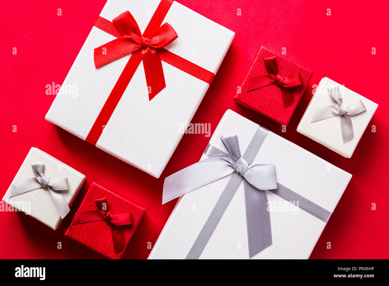 White and red gift boxes on red background. Top view Stock Photo - Alamy