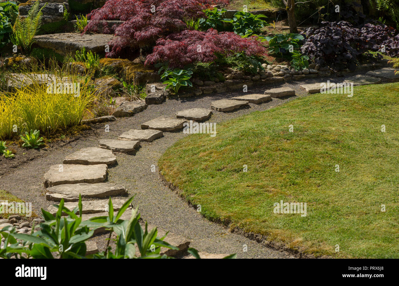 Path with rough hewn paving stones leading in a curve in an English ...
