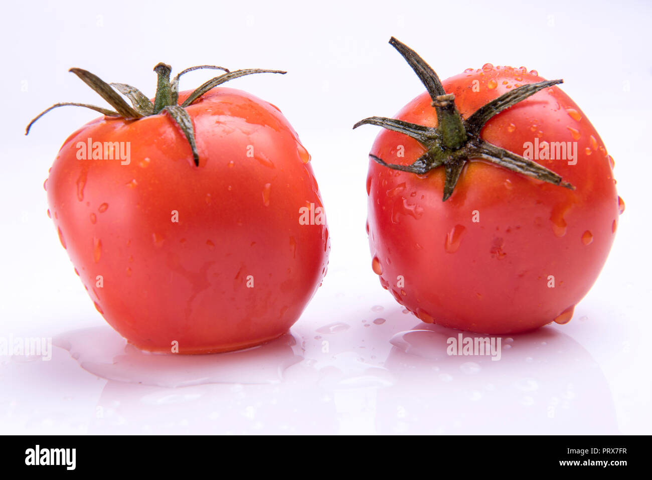 Two Tomato with water drops on it Isolated on a white background. at ...
