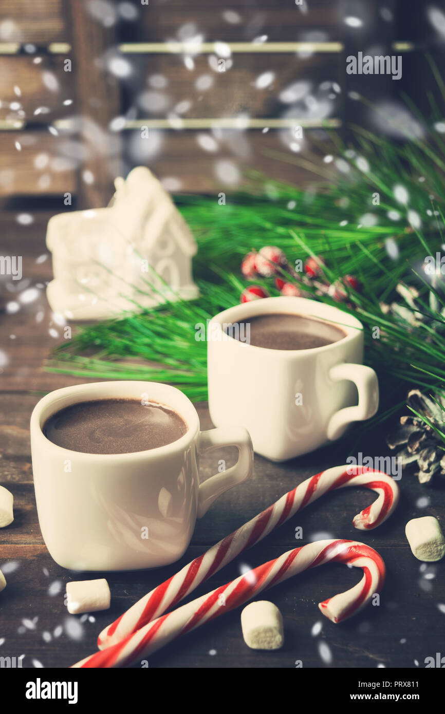 Hot winter drink in two white cups on wooden background with copy space ...