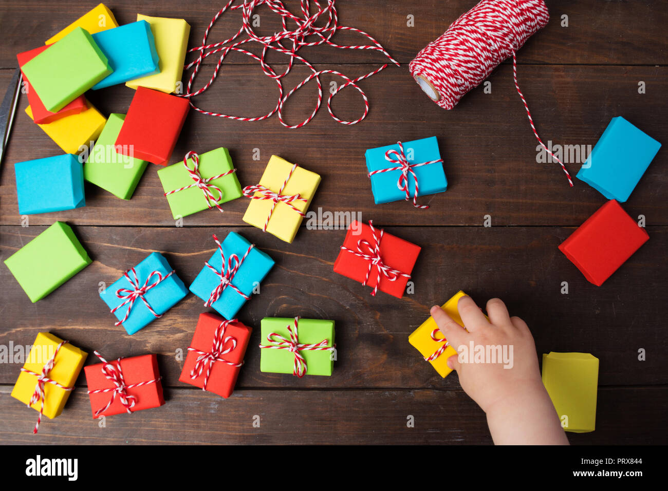 Many colorful small gift boxes with kids hand to take one box over ...