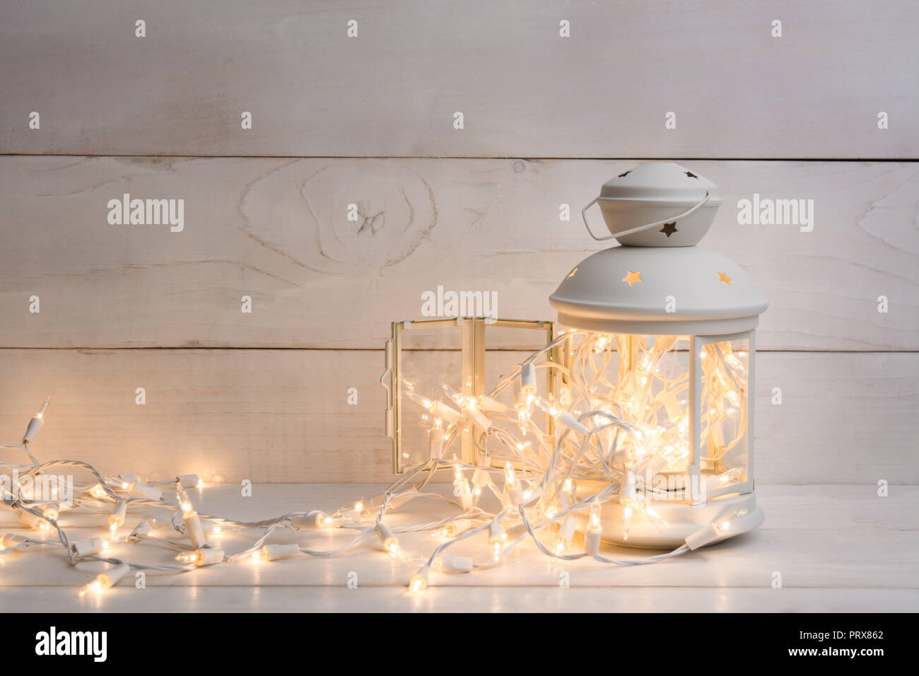 Open lantern with yellow warm light garland with copy space on white ...