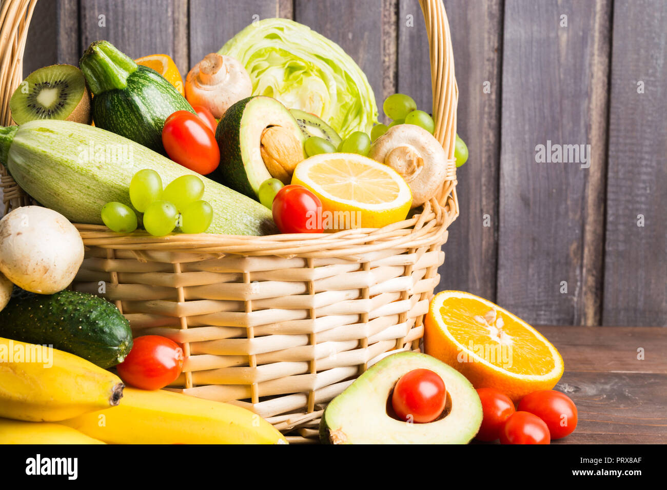 Rich fruits and vegetables with mushrooms in basket on wooden ...
