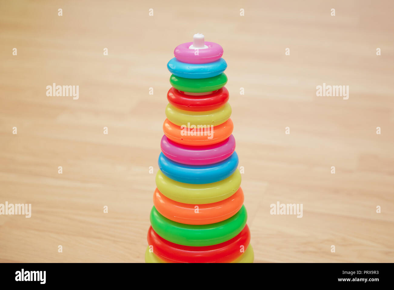 Pyramid build from colored wooden rings with a clown head on top. Toy ...