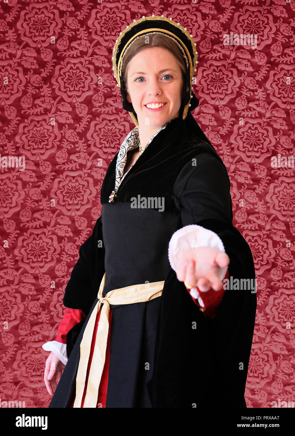Young woman dressed in Tudor period costume makes invitation to dance ...