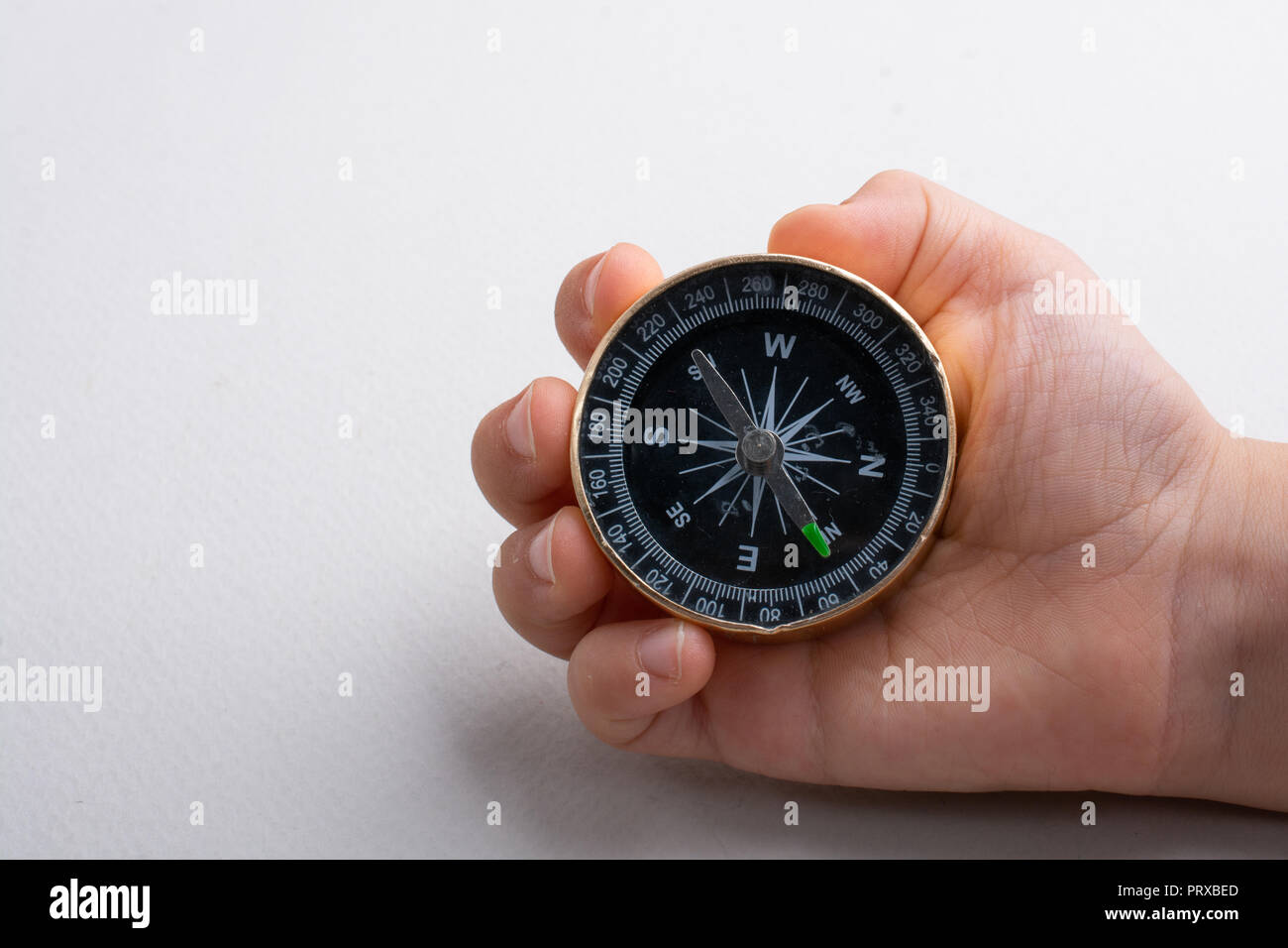 Compass tool in toddler hand on white Stock Photo - Alamy