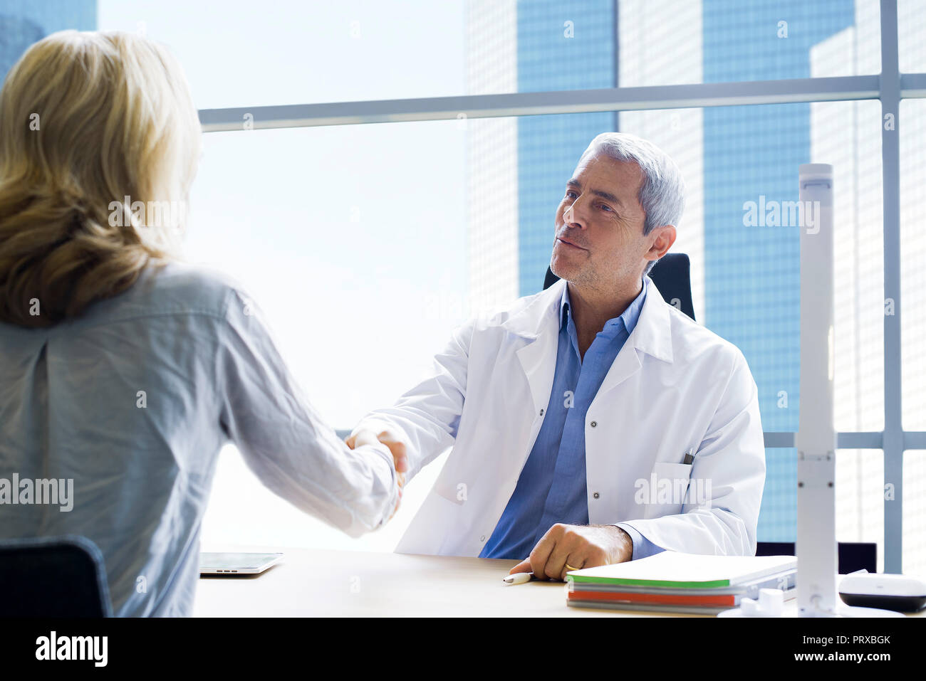 Doctor shaking hand with patient in clinic Stock Photo - Alamy