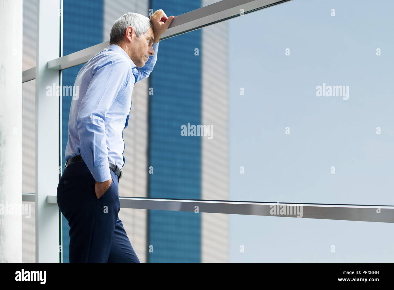 Businessman standing near window Stock Photo - Alamy