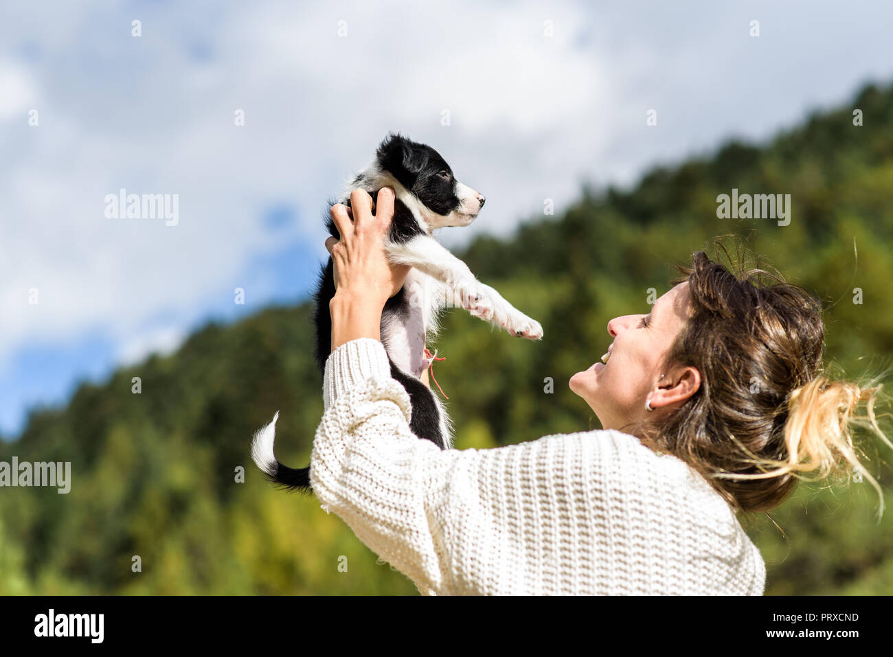 Young European woman playing with her black and white border collie ...