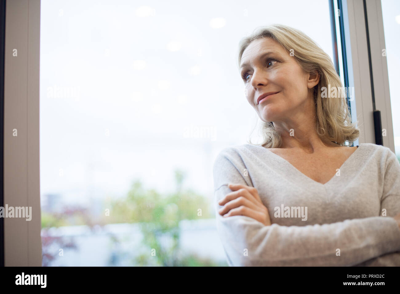 Businesswoman standing near window Stock Photo - Alamy