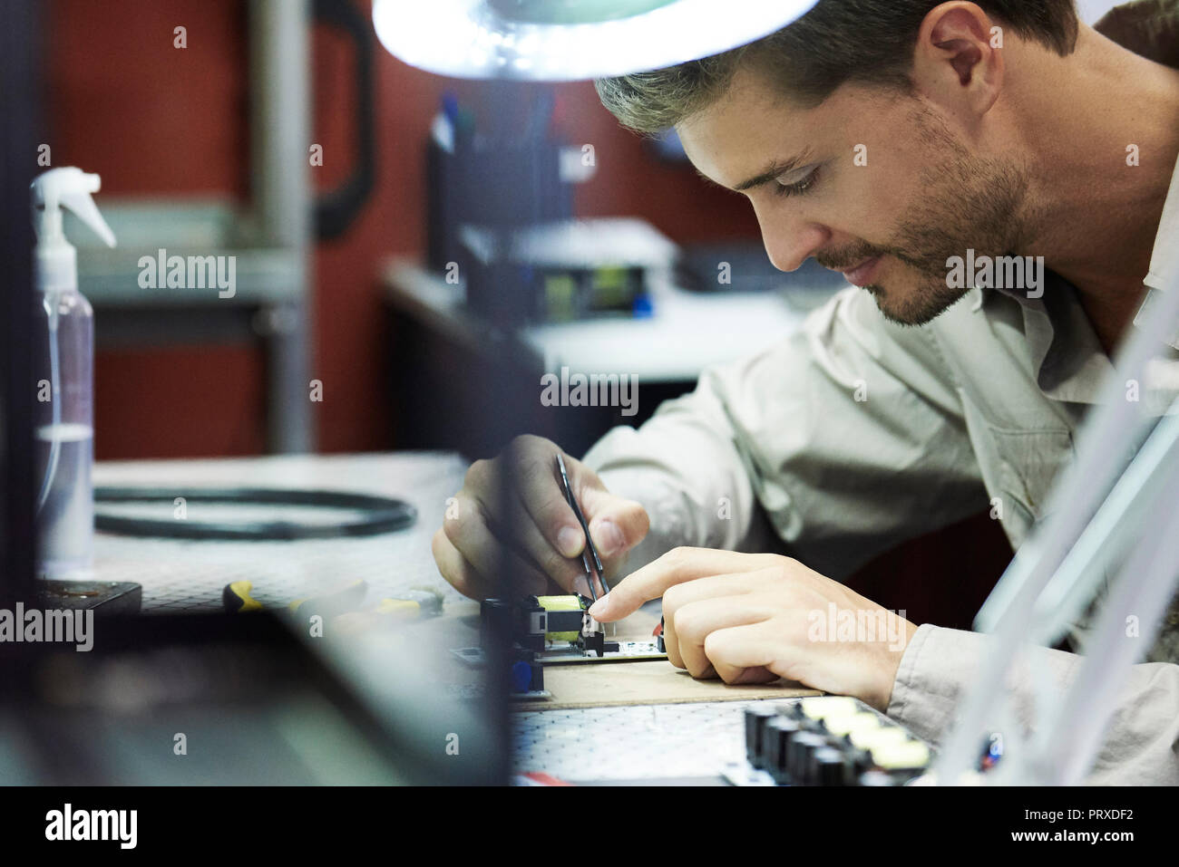 Engineer soldering circuit board in office Stock Photo - Alamy
