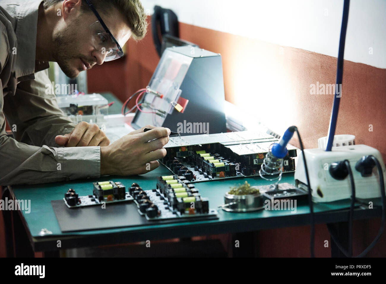 Engineer soldering circuit board in office Stock Photo - Alamy